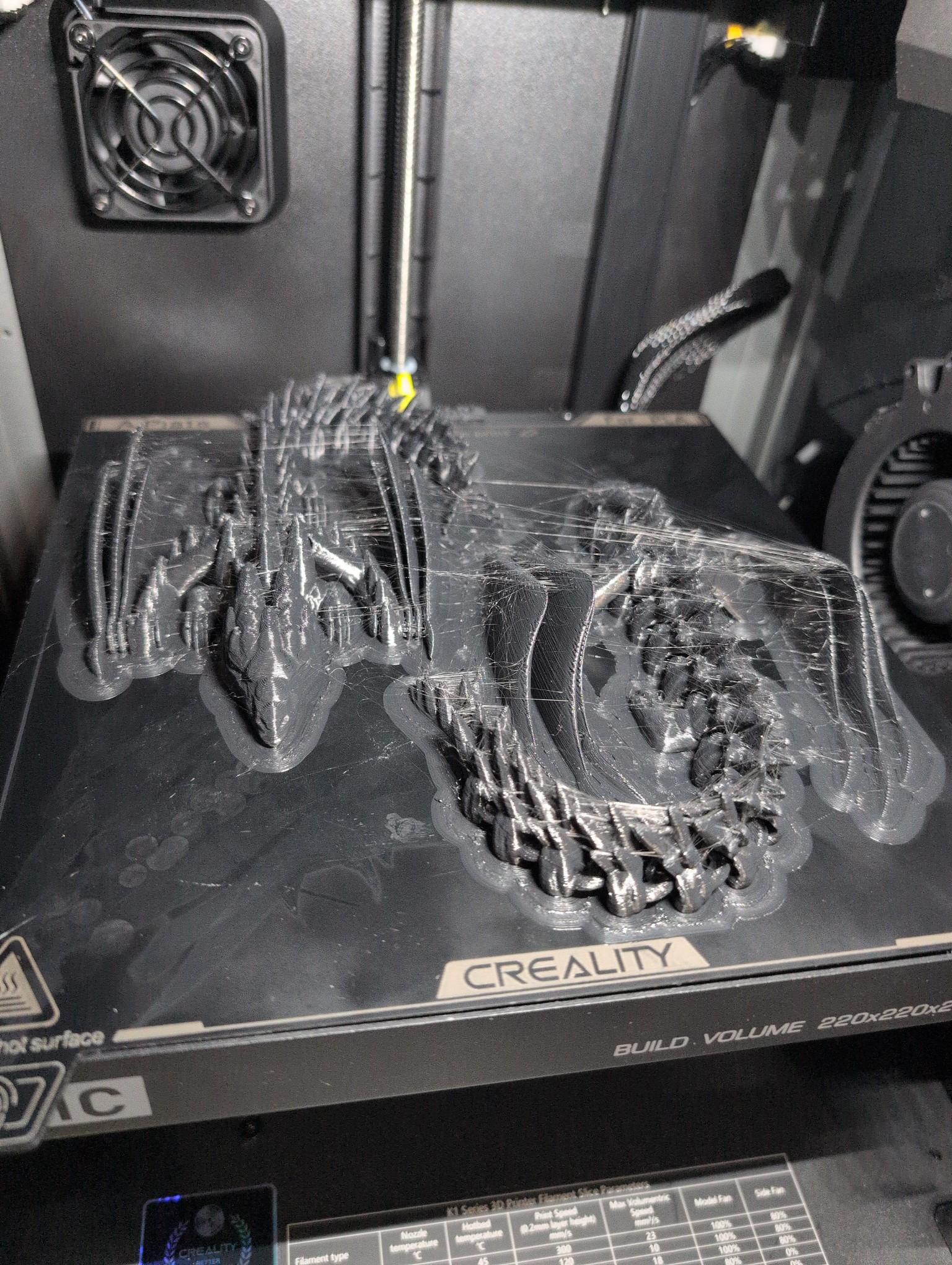 2 articulated dragons in black PLA. print in place with no supports and auto brim to help ...